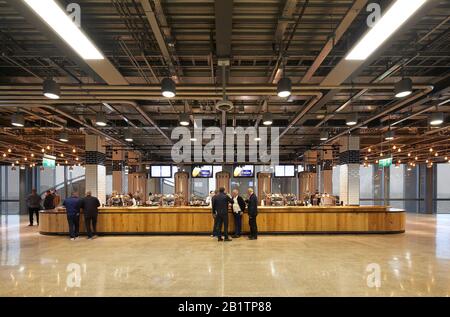 Pub-style feature bar for fans in concourse with window wall to stadium ...