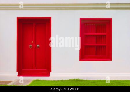 Intense blood red painted door and window on a white wall. Saturated ...