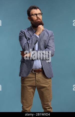 Portrait of skeptical young bearded man looking at camera isolated over ...