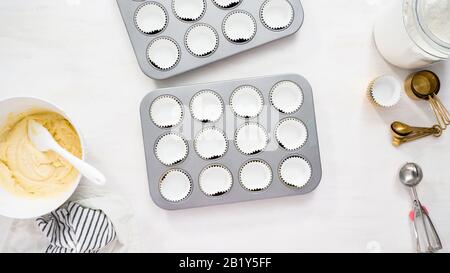 Flat lay. Step by step. Placing cupcake liners onto the cupcake pan to ...