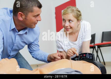Woman Demonstrating Recovery Position In First Aid Training Class Stock ...