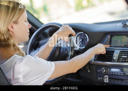 attractive woman changing radio station in her car Stock Photo - Alamy
