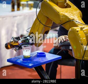 Futuristic robotic arm pouring beer into a glass Stock Photo - Alamy