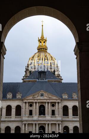 The golden dome of Les Invalides viewed from under the entrance archway ...