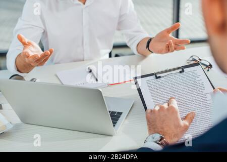 cropped view of translator working with businessman and documents in ...