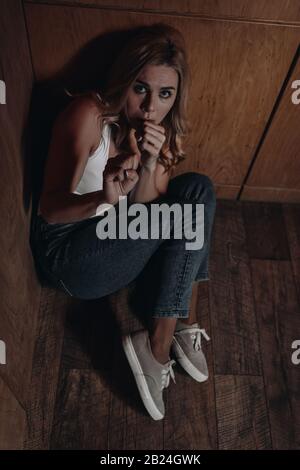 Scared woman hiding in corner Stock Photo - Alamy