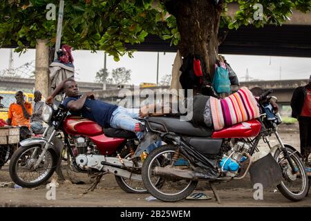 Motorcycle taxi (okada) drivers take a nap on their bikes in Nigeria ...