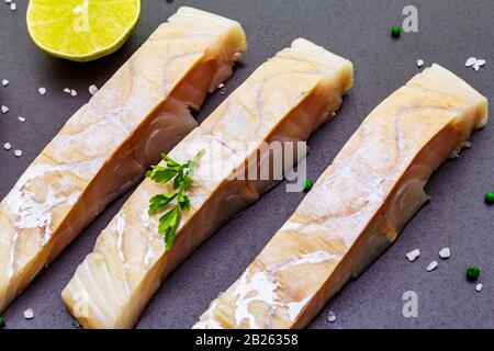 Fresh pollock pieces with lime, green pepper, salt and parsley. Concept ...