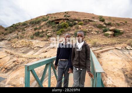 School boys crossing the Liphiring River to the Ha Baroana rock ...