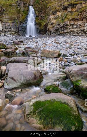 Beautiful coastal beach waterfall at the quaint village of Bucks Mills ...