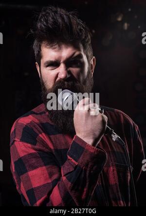 Vocalist concept. Musician with beard and mustache lighted by spotlight ...