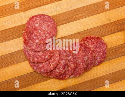Cured sausage meat is sliced placed on wooden board setting cozy ...