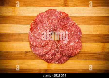 Cured sausage meat is sliced placed on wooden board setting cozy ...