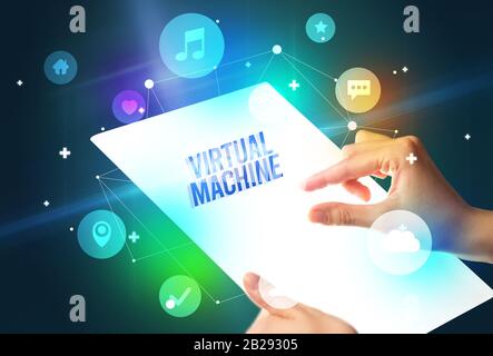 Holding futuristic tablet with VIRTUAL MACHINE inscription, new ...