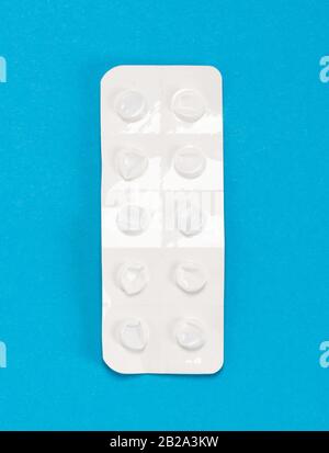 Pill strip isolated on a blue background Stock Photo - Alamy
