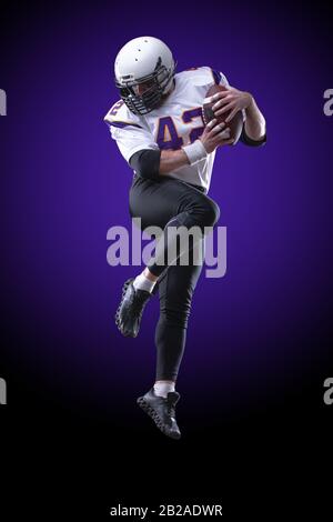 Football player in high jump taking ball Stock Photo - Alamy