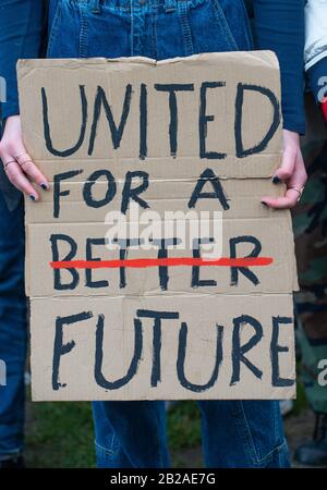 A climate activist holding a placard with a slogan expressing her ...