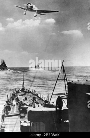 View of a warship in the ocean with other ships including a passenger ...