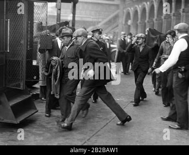 Prohibition: Policemen arrest a bootlegger who hid bottles with alcohol ...