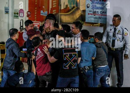 Manila, Philippines. 2nd Mar, 2020. Policemen and security guards grab ...