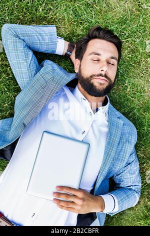Tired Young Man sleep with Tablet Computer on the Table Stock Photo - Alamy
