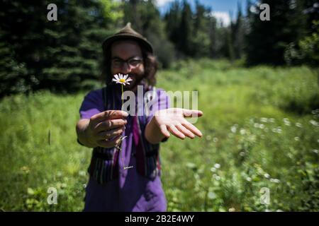 Young man with flower in mouth, portrait Stock Photo - Alamy