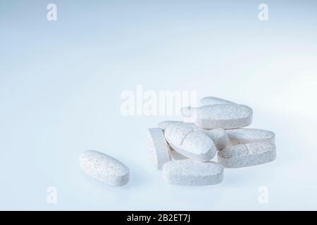 Close-up of a small cluster of elongated speckled tablets with single ...