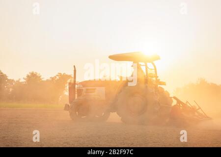 Thai farmer on big tractor in the land to prepare the soil for rice ...