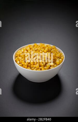 Frozen sweet corn in a bowl with a wooden spoon Stock Photo - Alamy