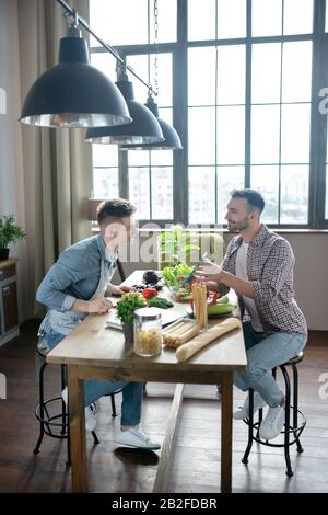 A couple sitting opposite each other at a table Stock Photo - Alamy
