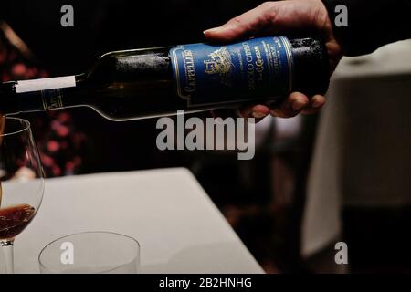Waiter pouring wine at Michelin restaurant La Sponda at the luxury Le ...