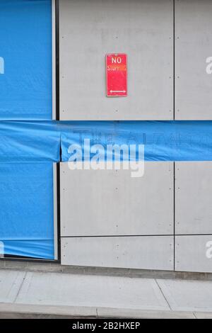 Red cladding panels on exterior of offices with shadow lines from slats ...