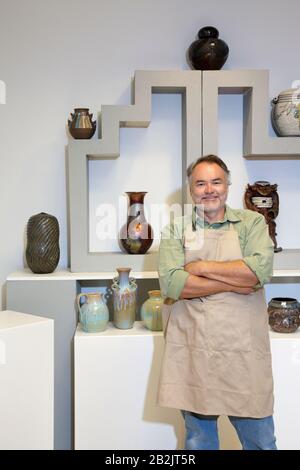 Male potter standing with arms crossed in pottery workshop Stock Photo ...