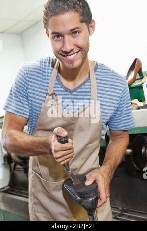 shoemaker hammering on a shoe in workshop Stock Photo - Alamy