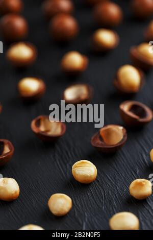 Purified and shell repeats macadamia nuts on black textural stone ...