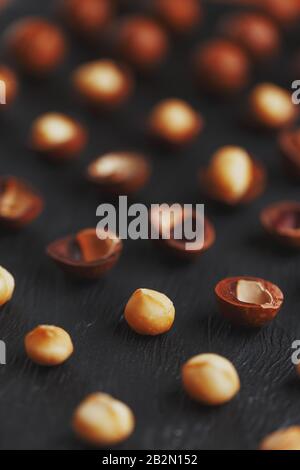 Purified and shell repeats macadamia nuts on black textural stone ...