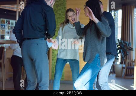 Colleagues dancing on corporate party with alcohol in hands Stock Photo ...