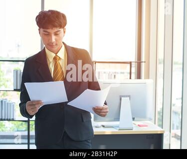 Asian businessman reading financial document in the office Stock Photo ...
