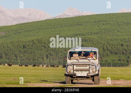 Russian jeep UAZ-469 driver trying to fix he`s car in steppe, Mongolia ...