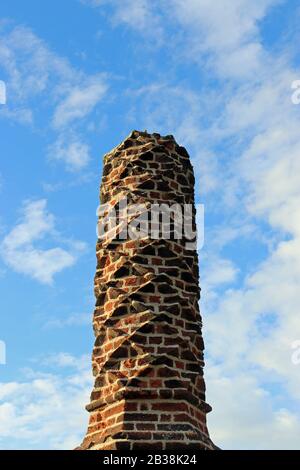 Tudor twisted barley sugar chimney pot on chimney stack with flint, red ...