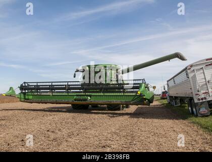 John Deere S670 combine is dumping its hopper load into a semi Stock ...