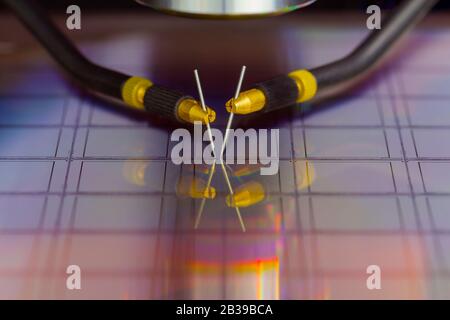 Close up of examining a sample of microchip transistor with probe ...