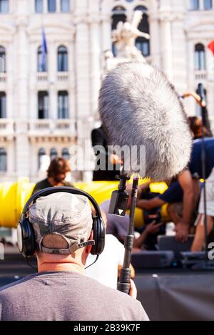 Behind the scene. Sound boom operator resting on the set and hold ...