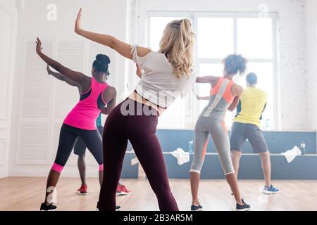 Back view of multiethnic dancers performing zumba movements in dance ...
