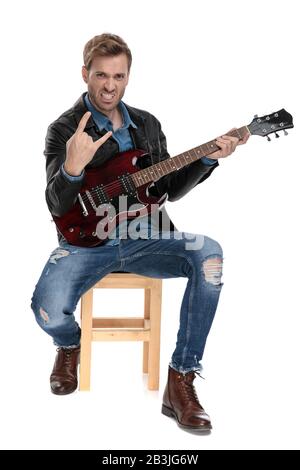 Man making rocker gesture, on white background. Young adult young man ...