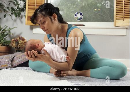 Austin, Texas USA, 1993: New mom in exercise attire looking into eyes ...