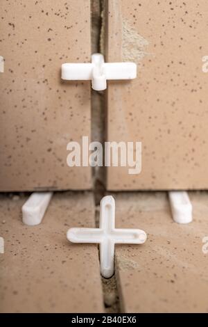 Plastic crosses that position the tiles when laying. The process of ...