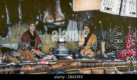 An elderly Ainu woman in traditional dress shows off her prized ...