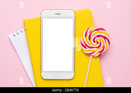 Colorful lolipop with notebook, pink, yellow and white spiral on pink ...