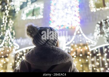 Fashionable female enjoying christmas spirit in front of house with ...